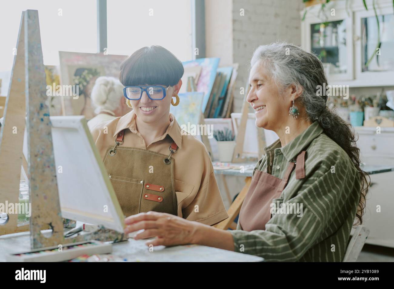 Young adult Caucasian teacher interacting with senior female student ...
