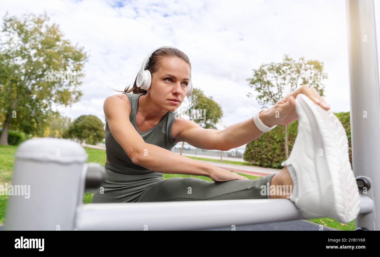 Motivated fitness enthusiast performing stretching exercises outdoors ...
