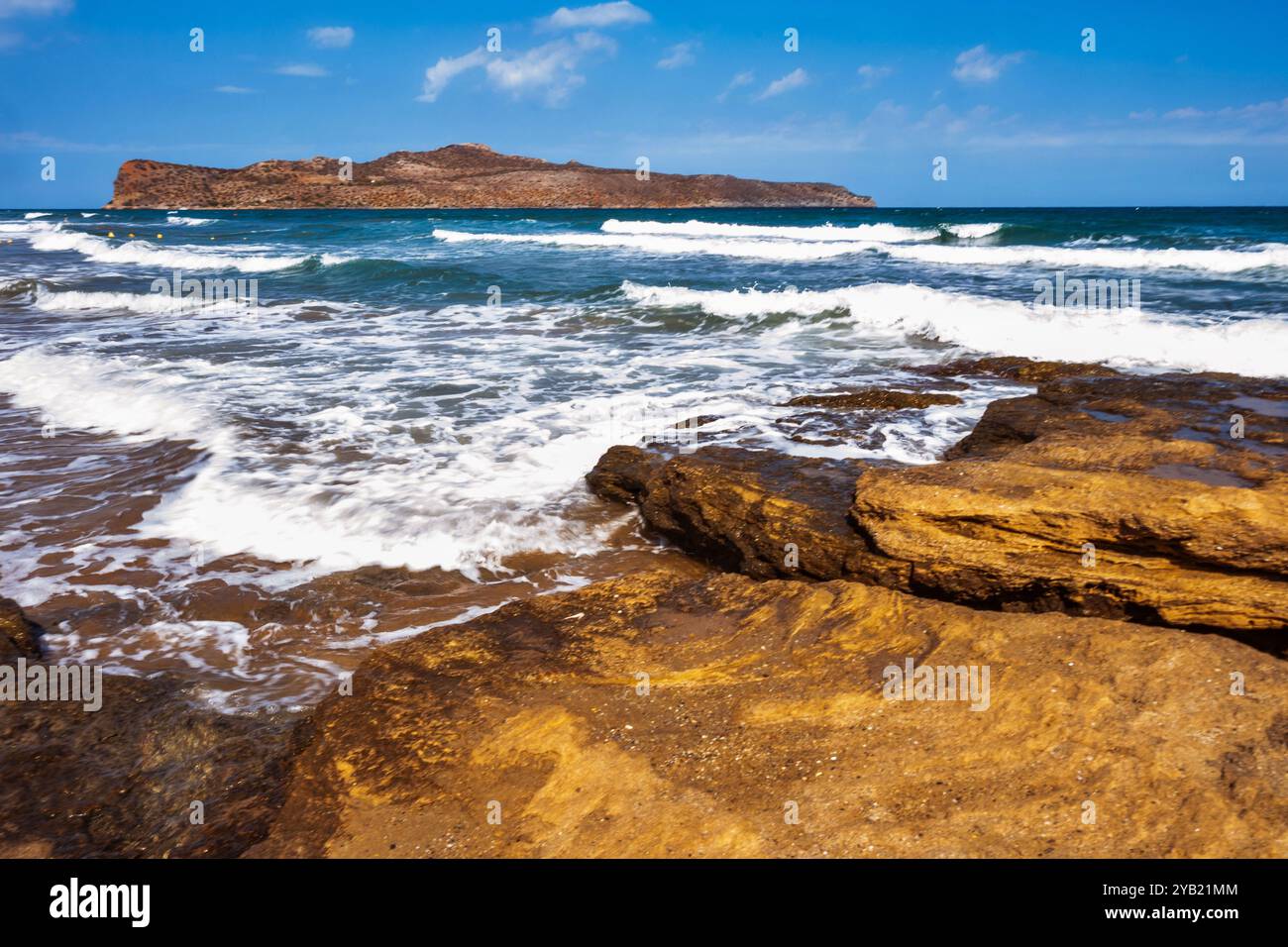 Sunny summer day on coastline area of Kato Stalos, wave and rock in ...