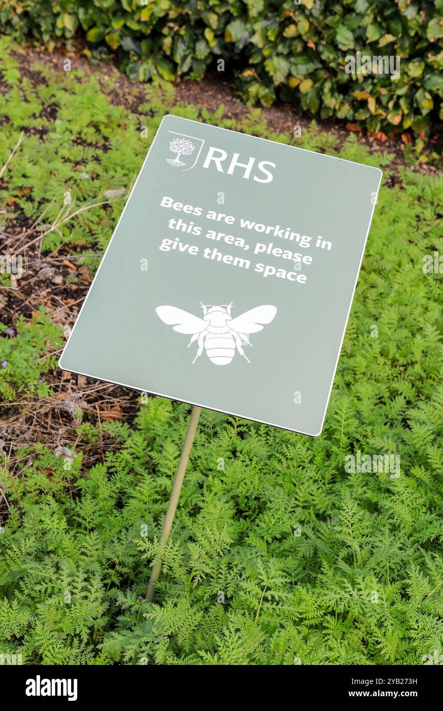 A sign saying "Bees are working in this area, please give them space ...