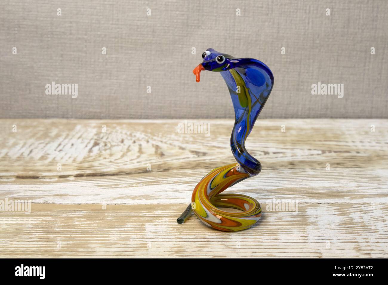 Figurine of snake from glass on rough wooden background front view ...