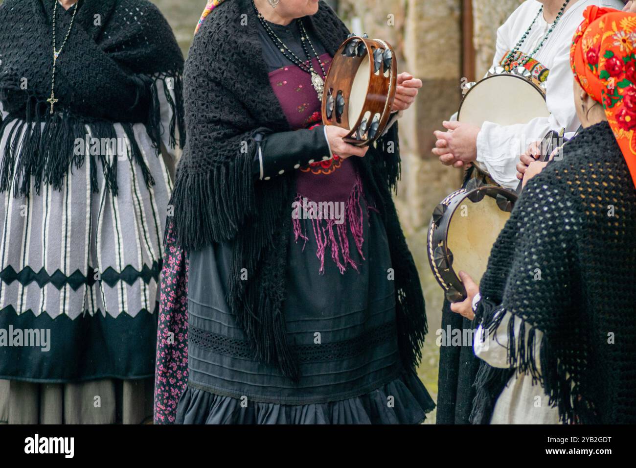 women dressed in traditional costume in Galicia playing the tambourine ...
