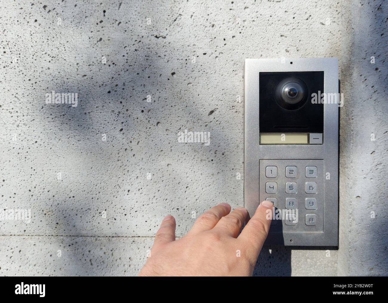 Hand pressing keypad on modern intercom device Stock Photo - Alamy