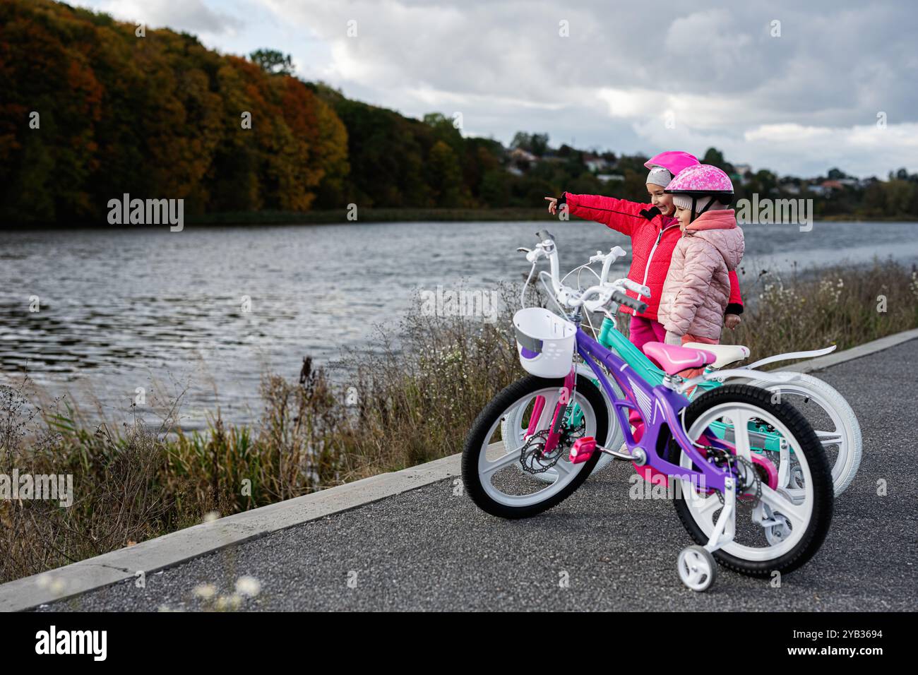 Two children on a lakeside pathway pause during their bike ride to ...