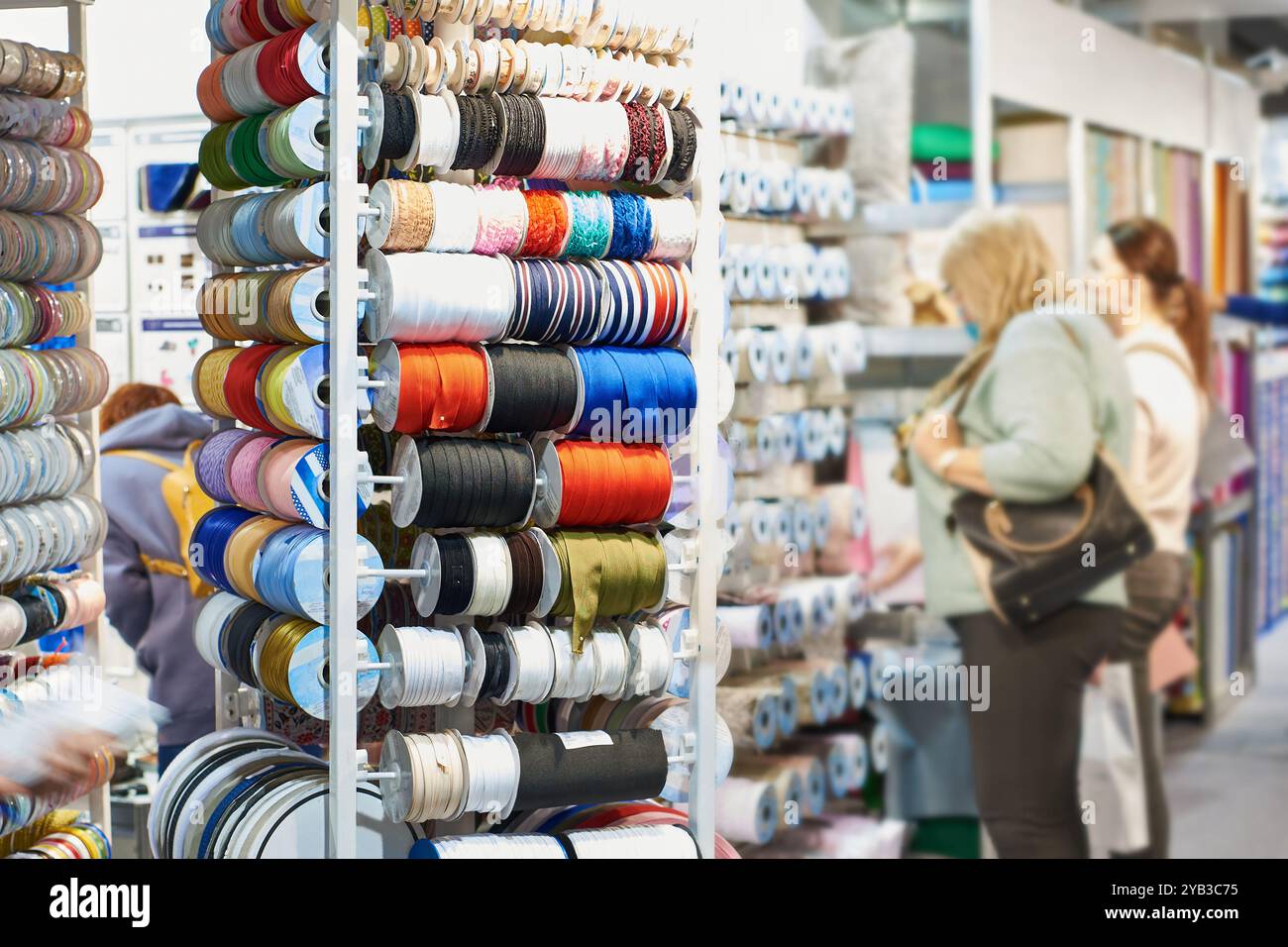 Woman shoppers choose fabric goods in textile store Stock Photo - Alamy