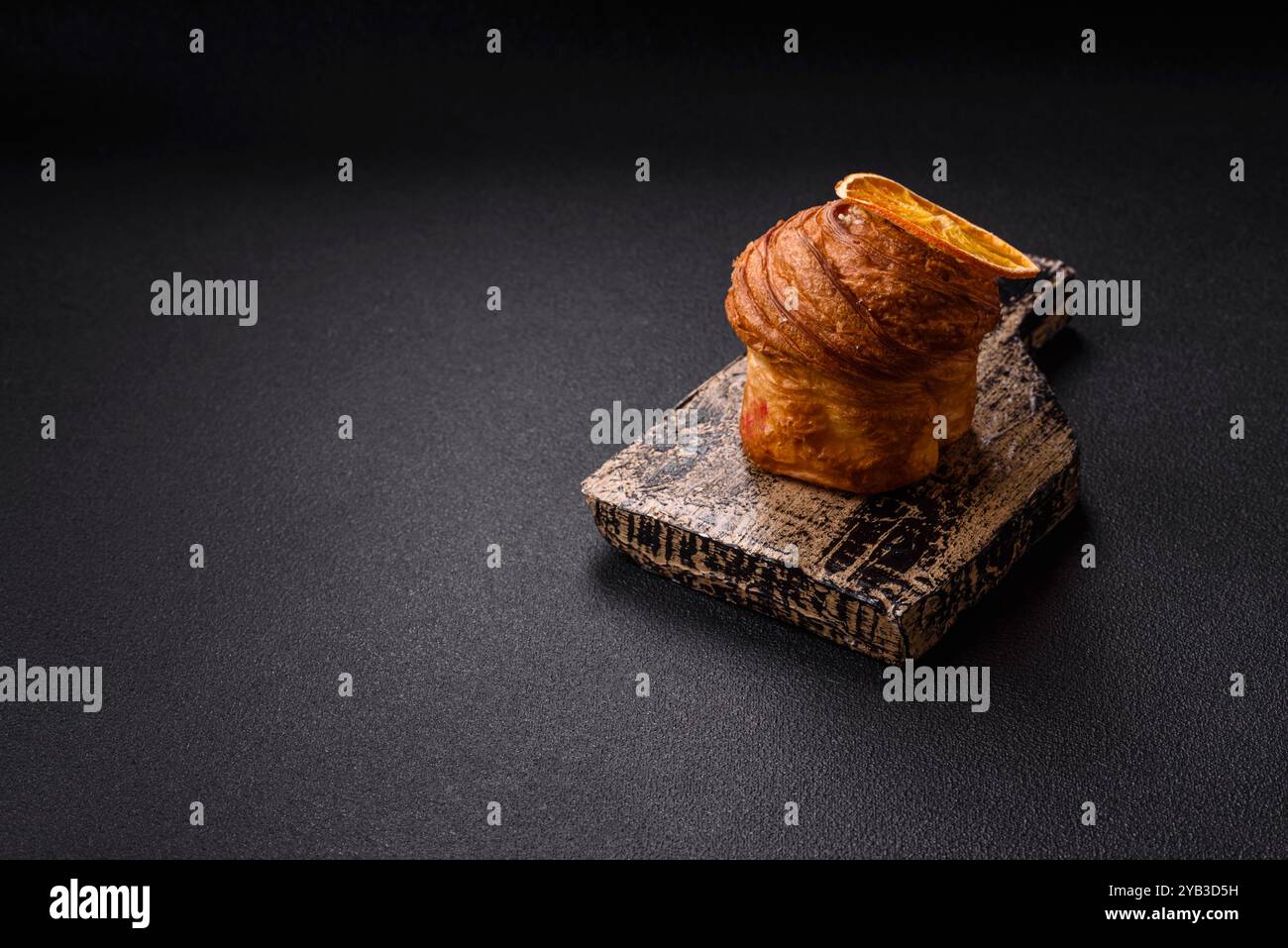 Sweet craffin made from puff pastry with Swiss meringue on a dark ...