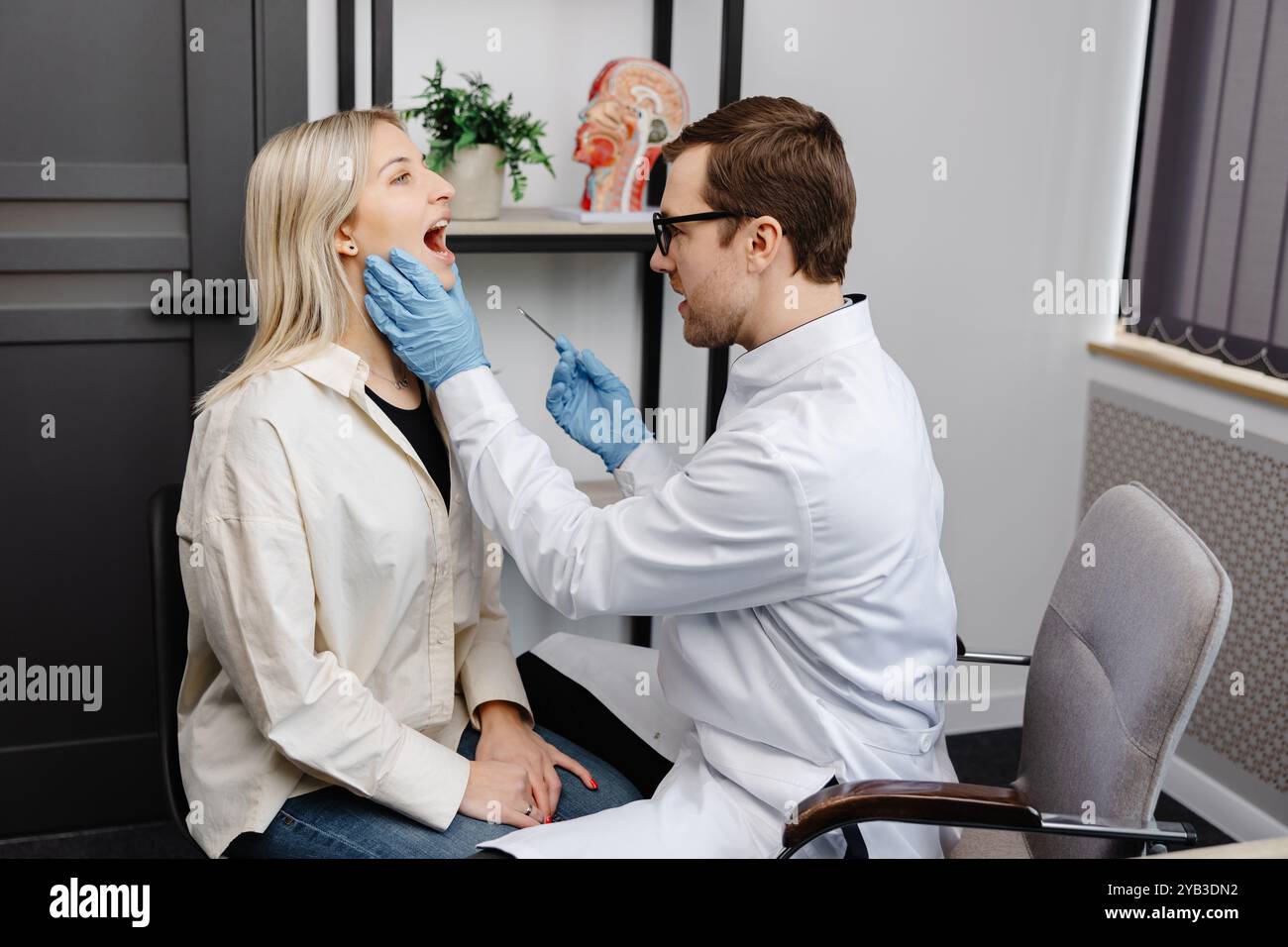 Doctor using inspection spatula to examine patient throat. ENT doctor ...