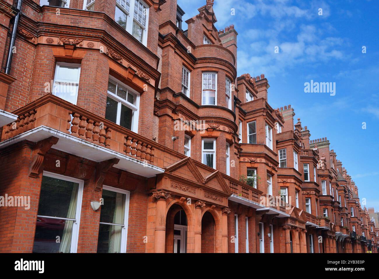 Long row of elegant brown brick townhouses in London Stock Photo - Alamy