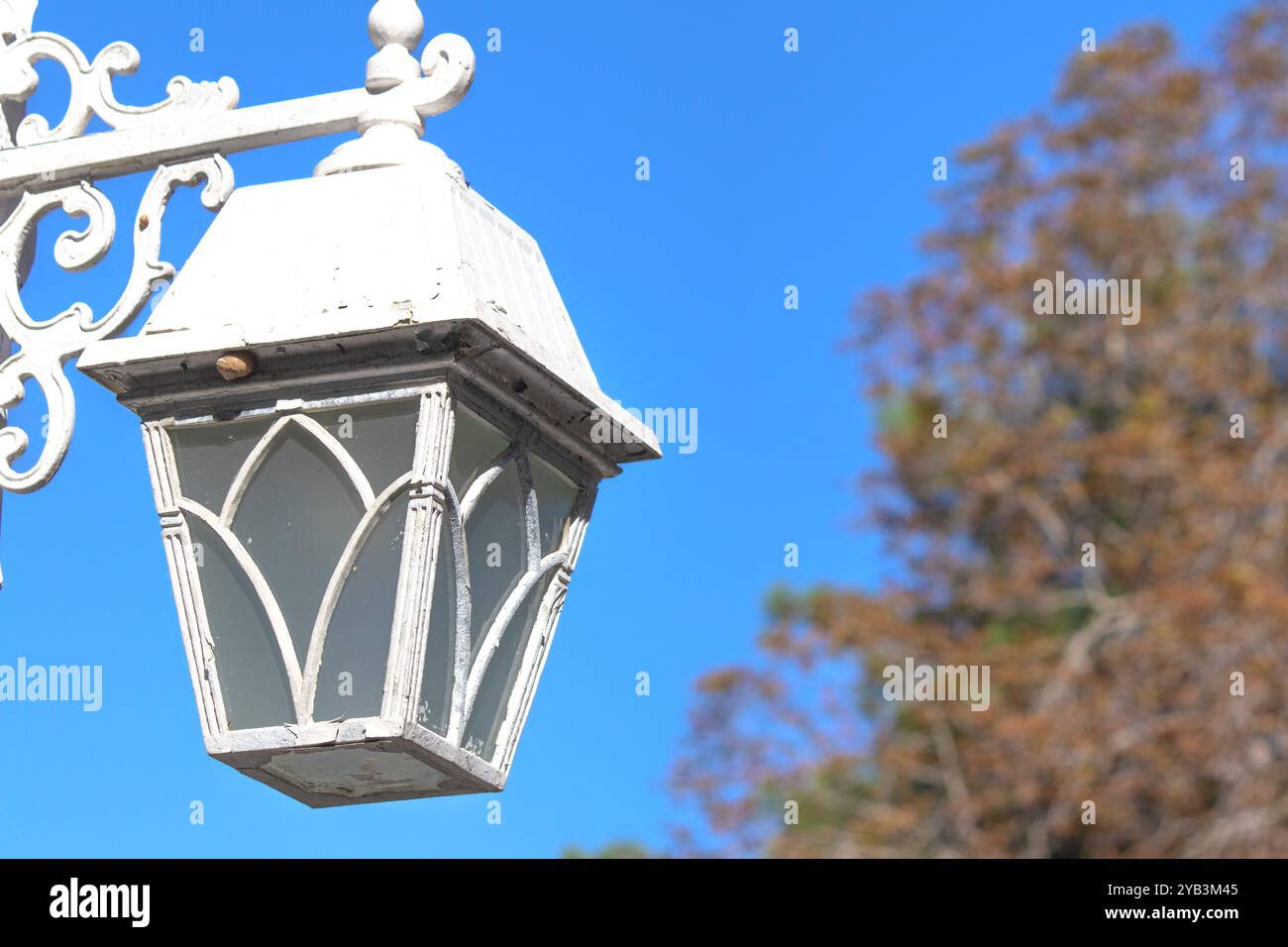 White vintage street lamp. Metal street lamp in front of blue sky ...