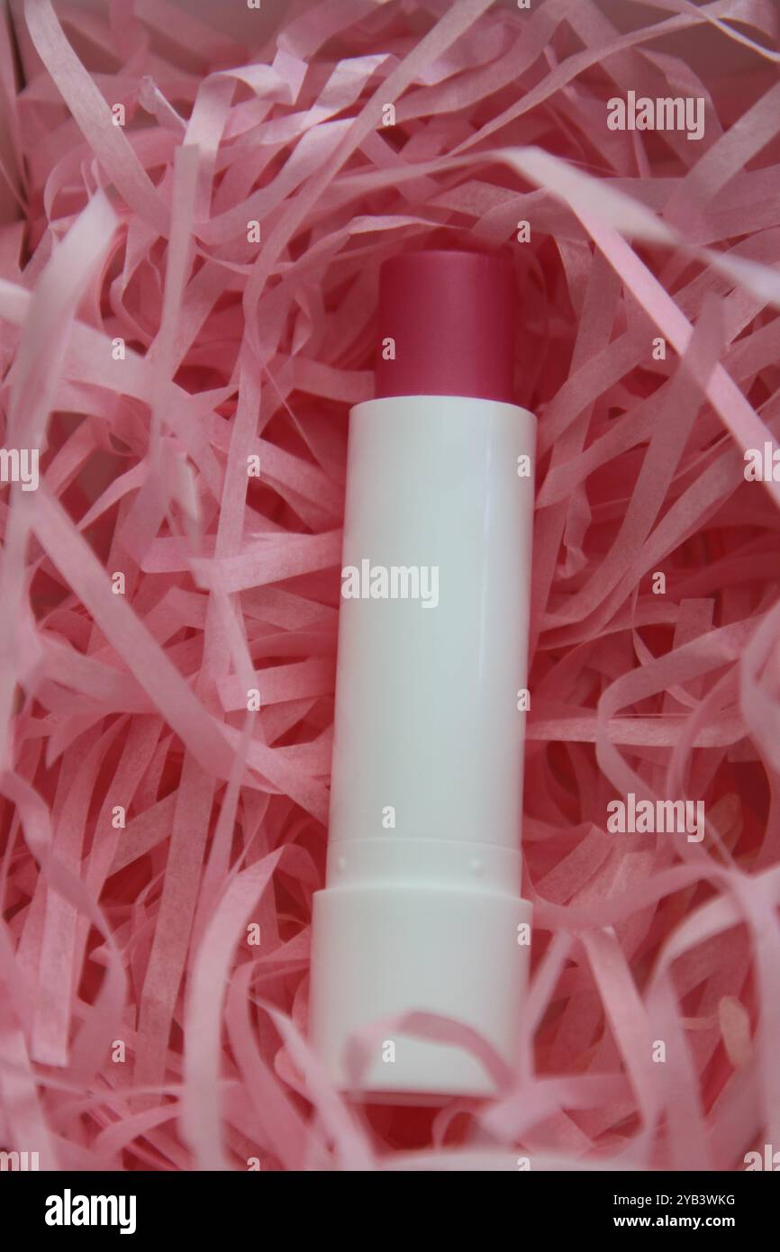 Pink hygienic lipstick with pink crinkled paper shred Stock Photo - Alamy