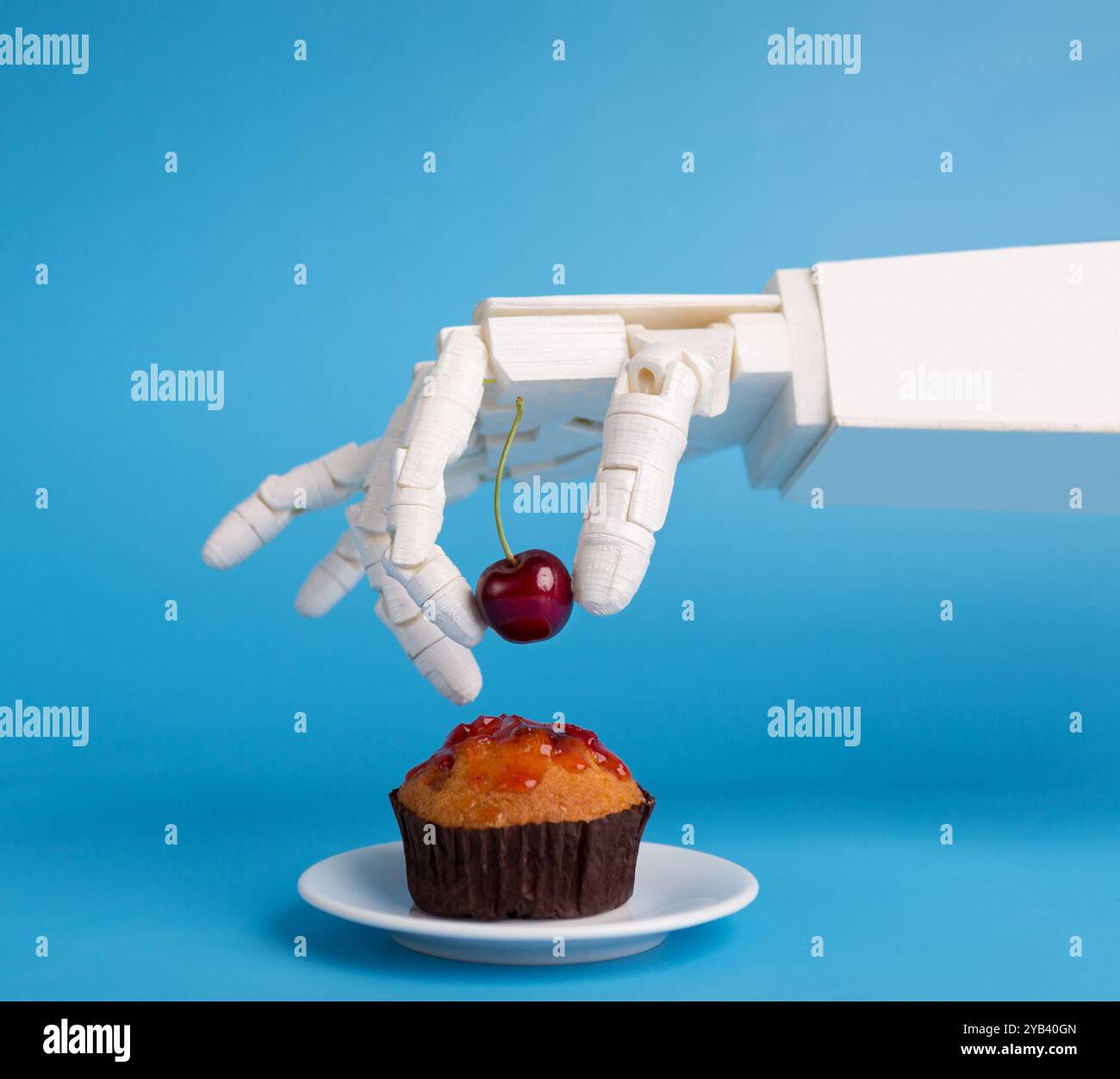 Robot hand decorating sweet cupcake with fresh cherry Stock Photo - Alamy