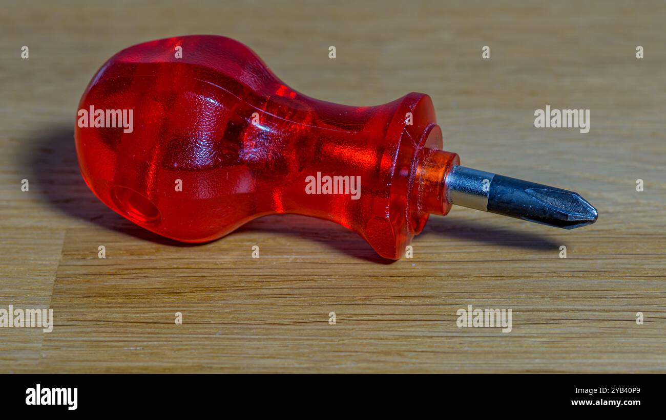 little red screwdriver on a wooden background Stock Photo - Alamy