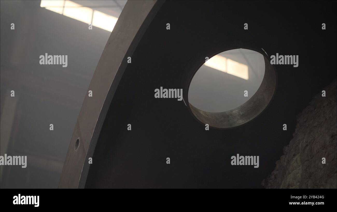 Large metal pipe in an industrial plant. A huge wrought iron pipe in a ...