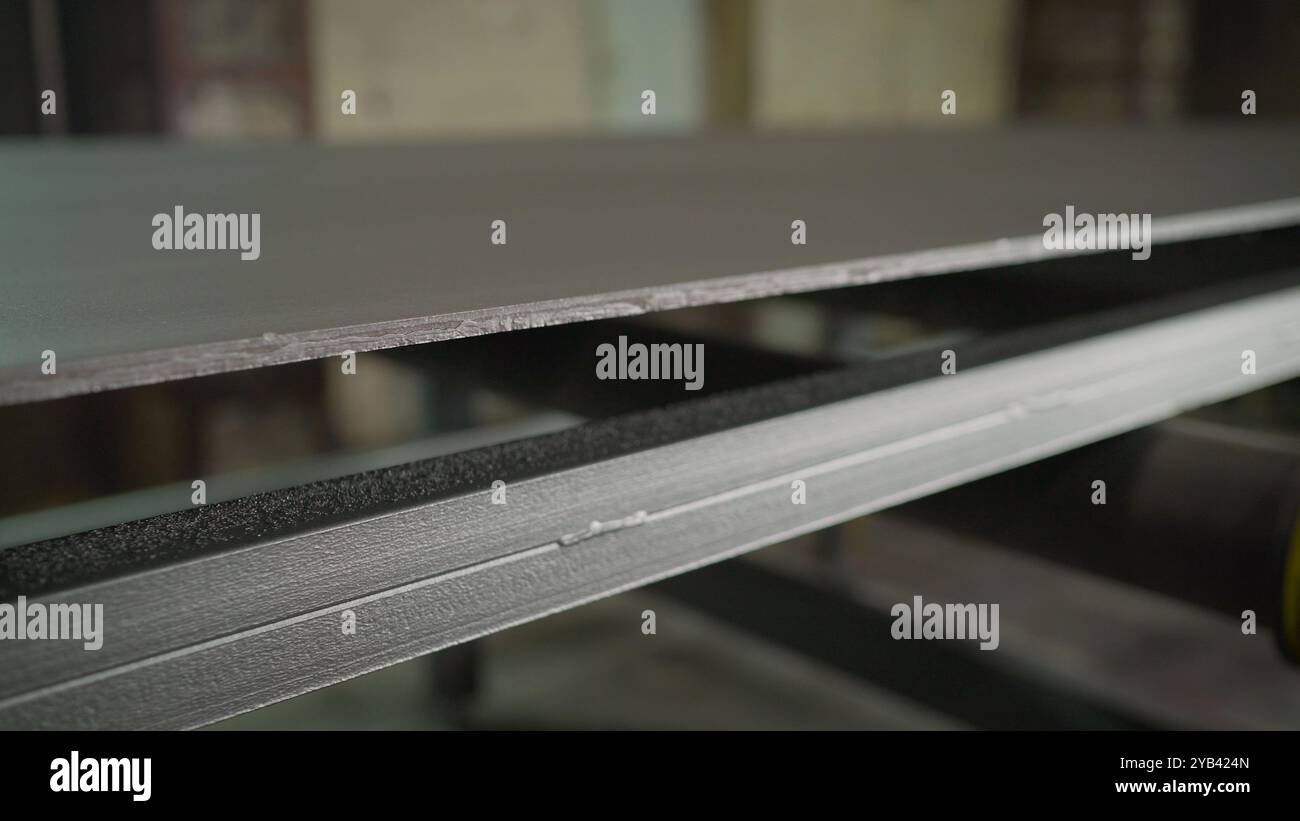 Metal sheet on the conveyor. Painting large metal sheets in a factory ...