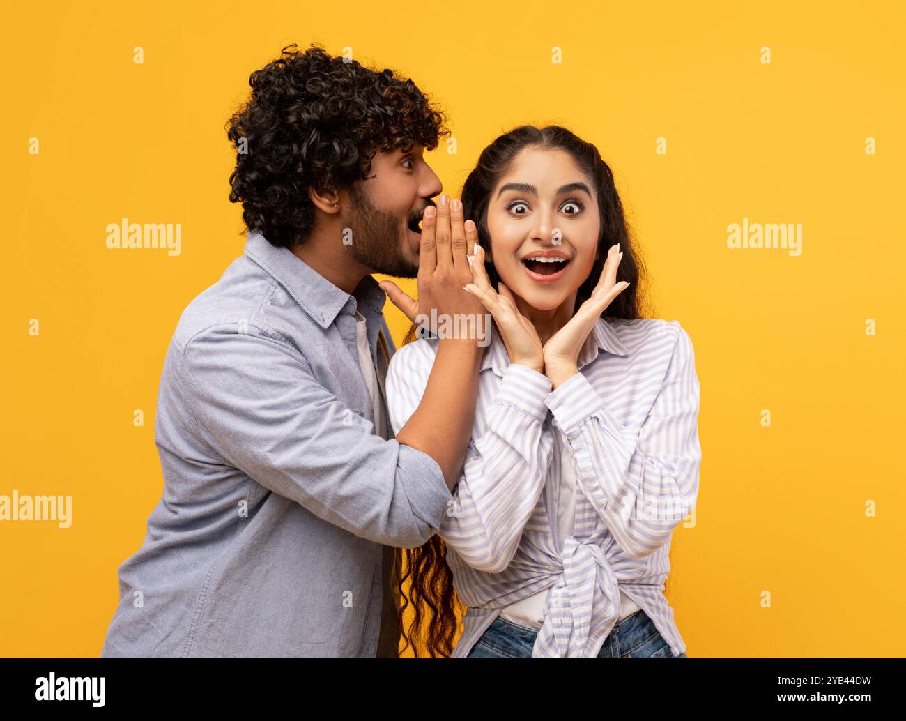 Shock, gossip, share advice. Young indian man whispering to lady on ear ...