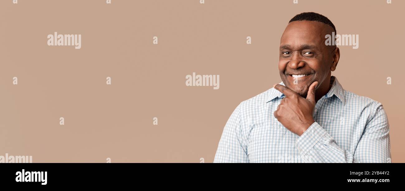 Flirty middle aged african man smiling at camera Stock Photo - Alamy