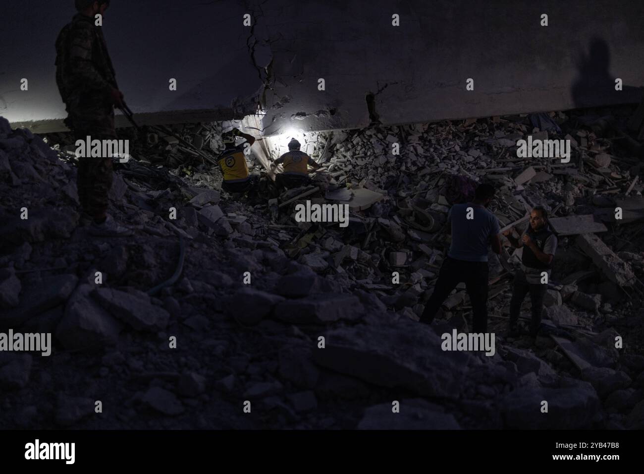 Idlib, Syria. 16th Oct, 2024. Members of the Syrian Civil Defense carry ...