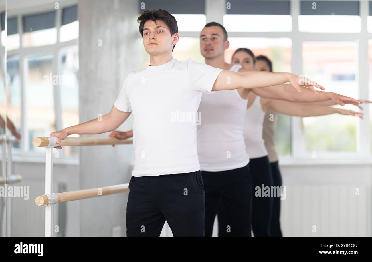 Group of dancers stand in second position at barre Stock Photo - Alamy