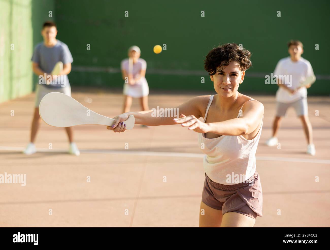 Portrait of sporty girl playing paleta fronton on outdoor court, ready ...