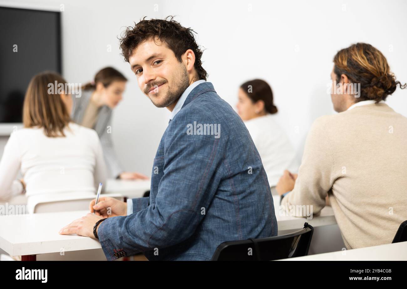 Positive young man turning around and looking at camera during advanced ...