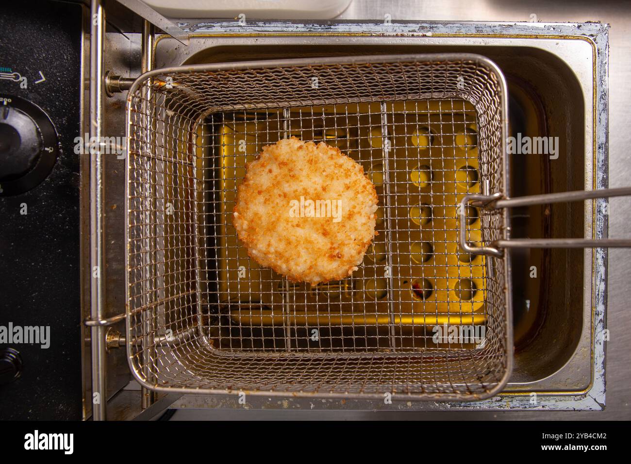 Fried cutlet in fryer basket in restaurant kitchen Stock Photo - Alamy