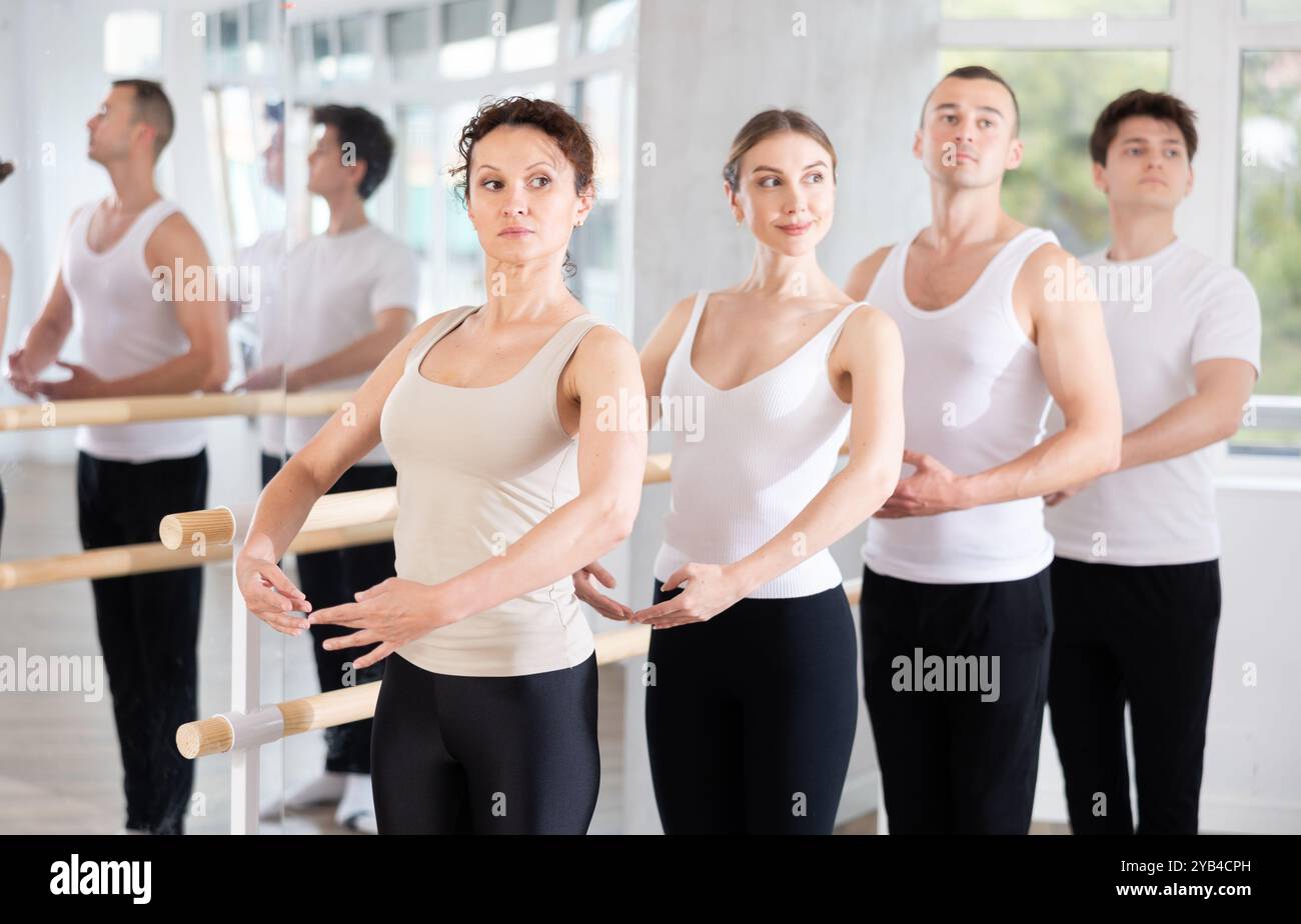 Group of dancers stand in first position at barre Stock Photo - Alamy