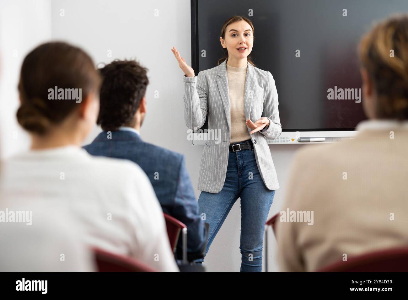 Young female teacher giving lecture to group of student Stock Photo - Alamy