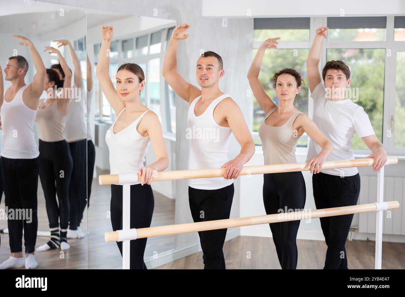 Group of dancers stand in third position at barre Stock Photo - Alamy