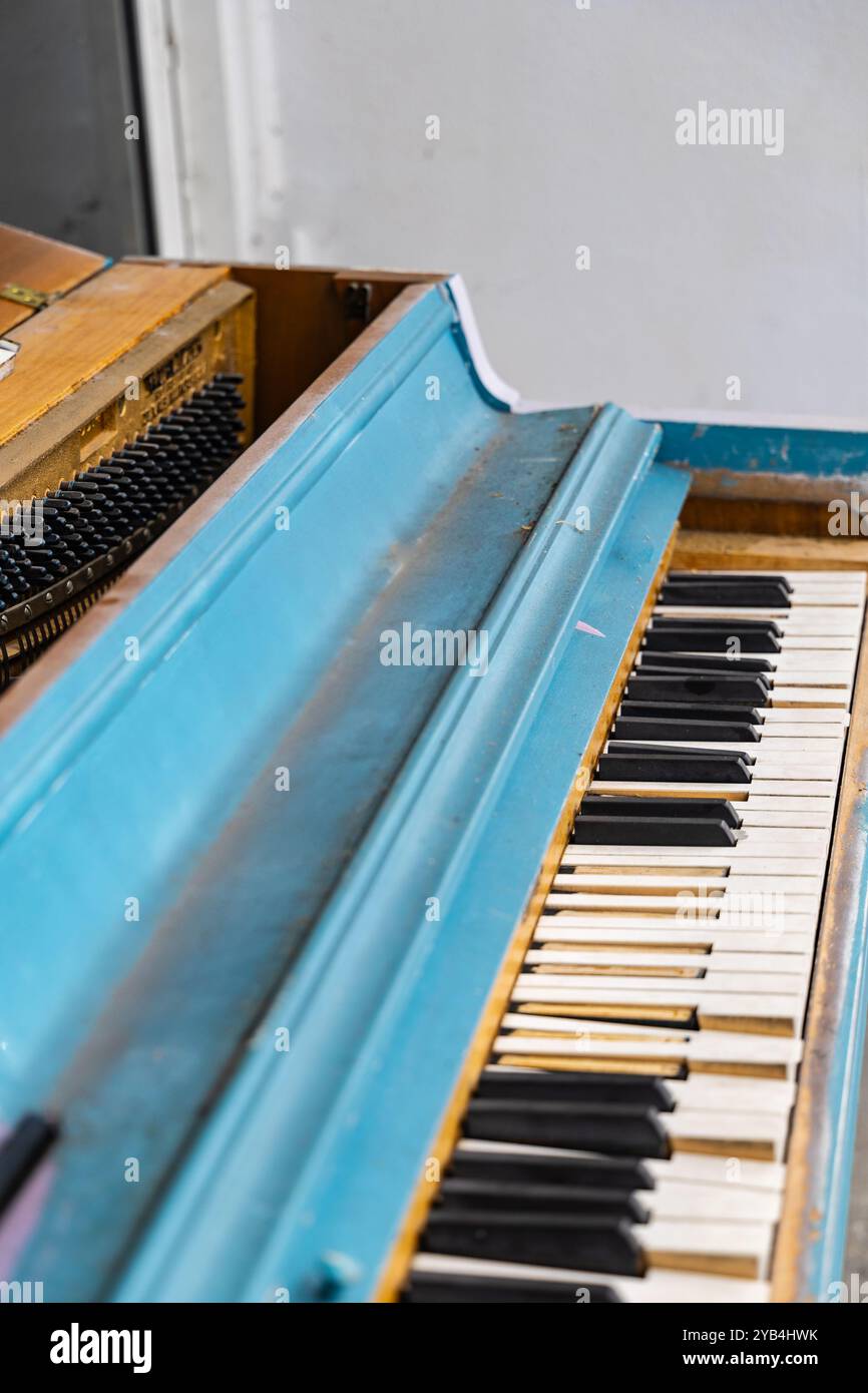 Old antique piano missing keys with obvious wood water damage. A ...