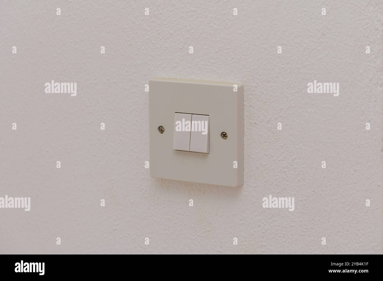 The light switch is positioned on a plain white wall, ready to bring ...