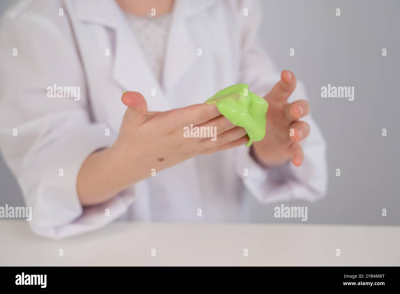 Faceless girl doing chemical experiments on a white background. Making ...