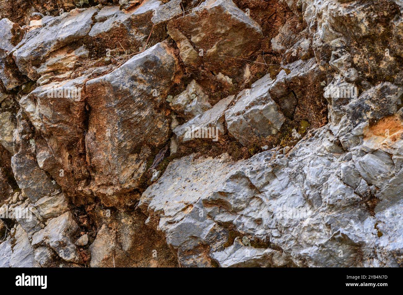 A detailed view of a natural rock formation displays various layers of ...