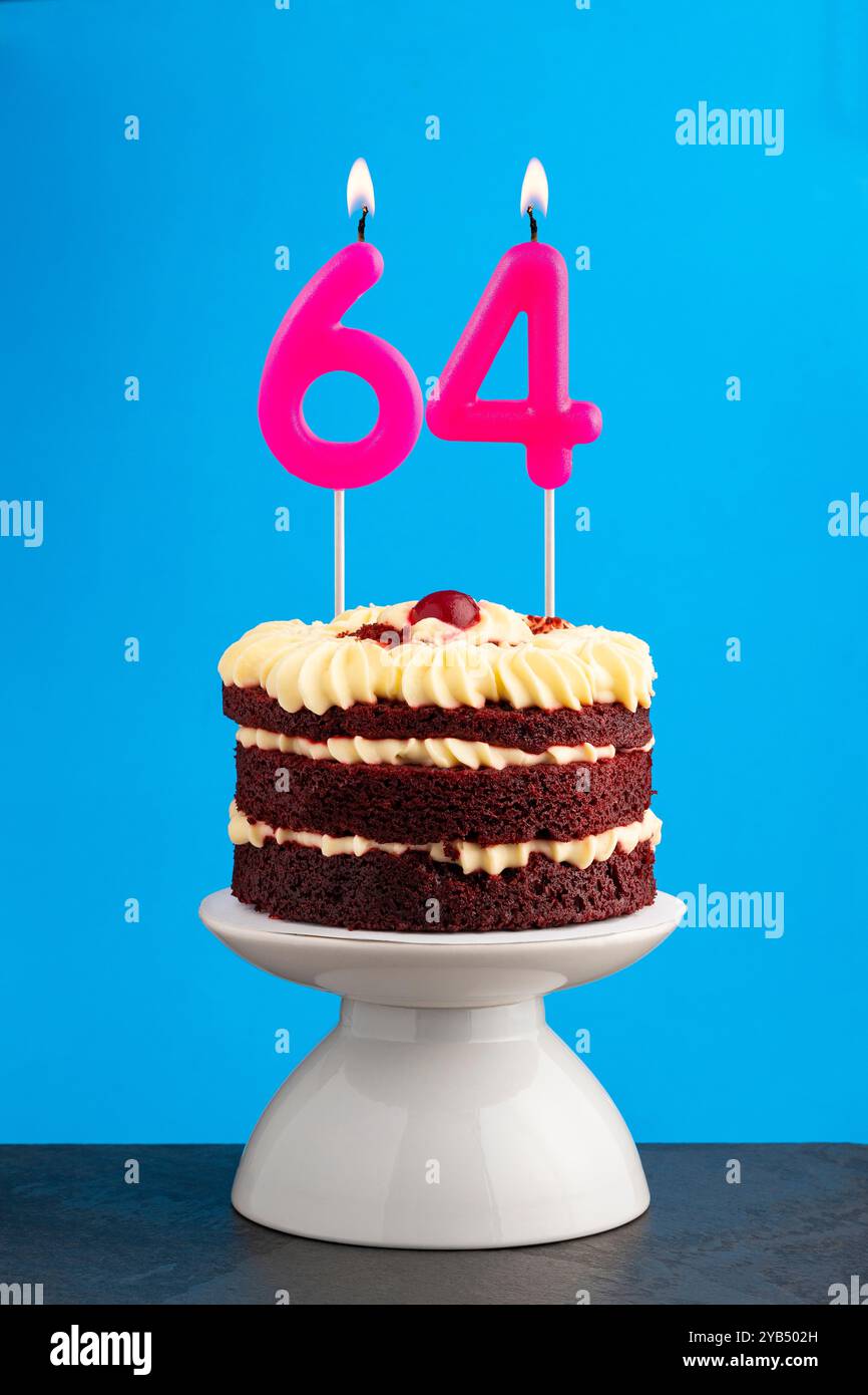 Red velvet birthday cake with number 64 candle Stock Photo - Alamy