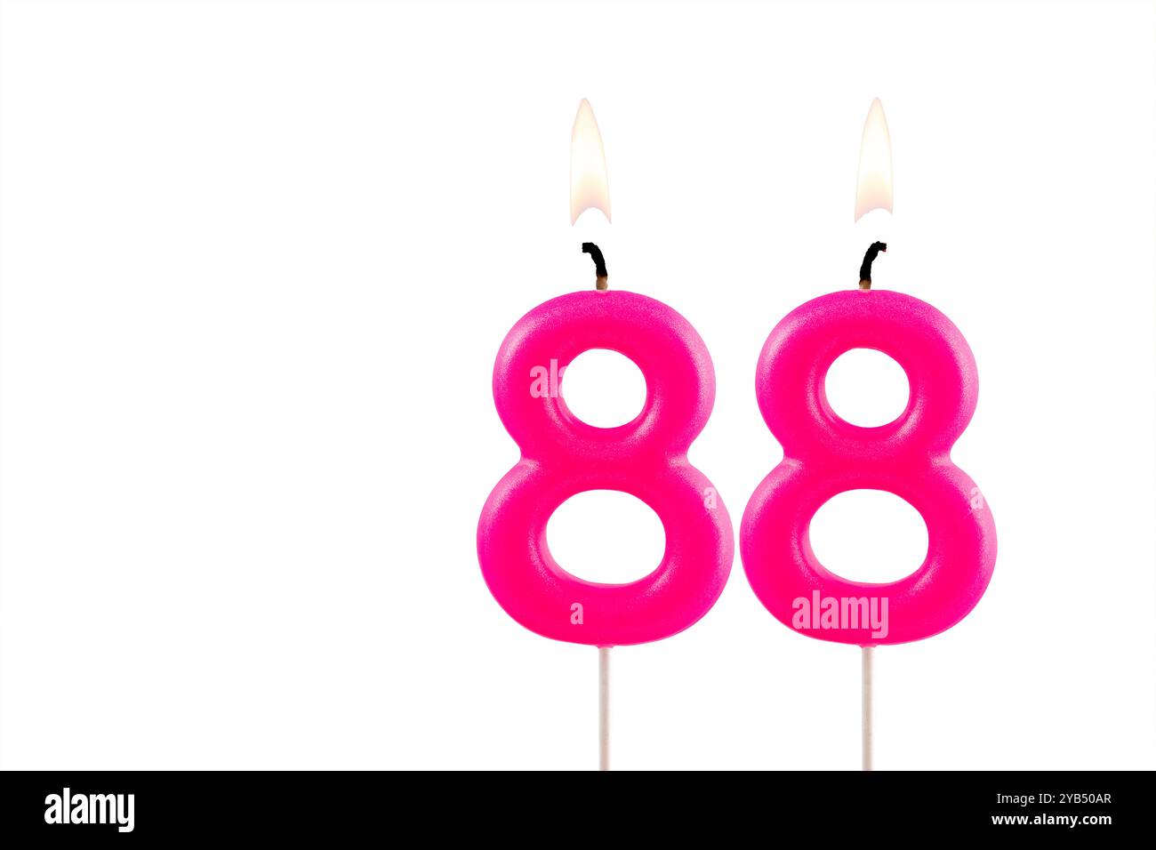 Pink number 88 birthday candle lit on white background Stock Photo - Alamy