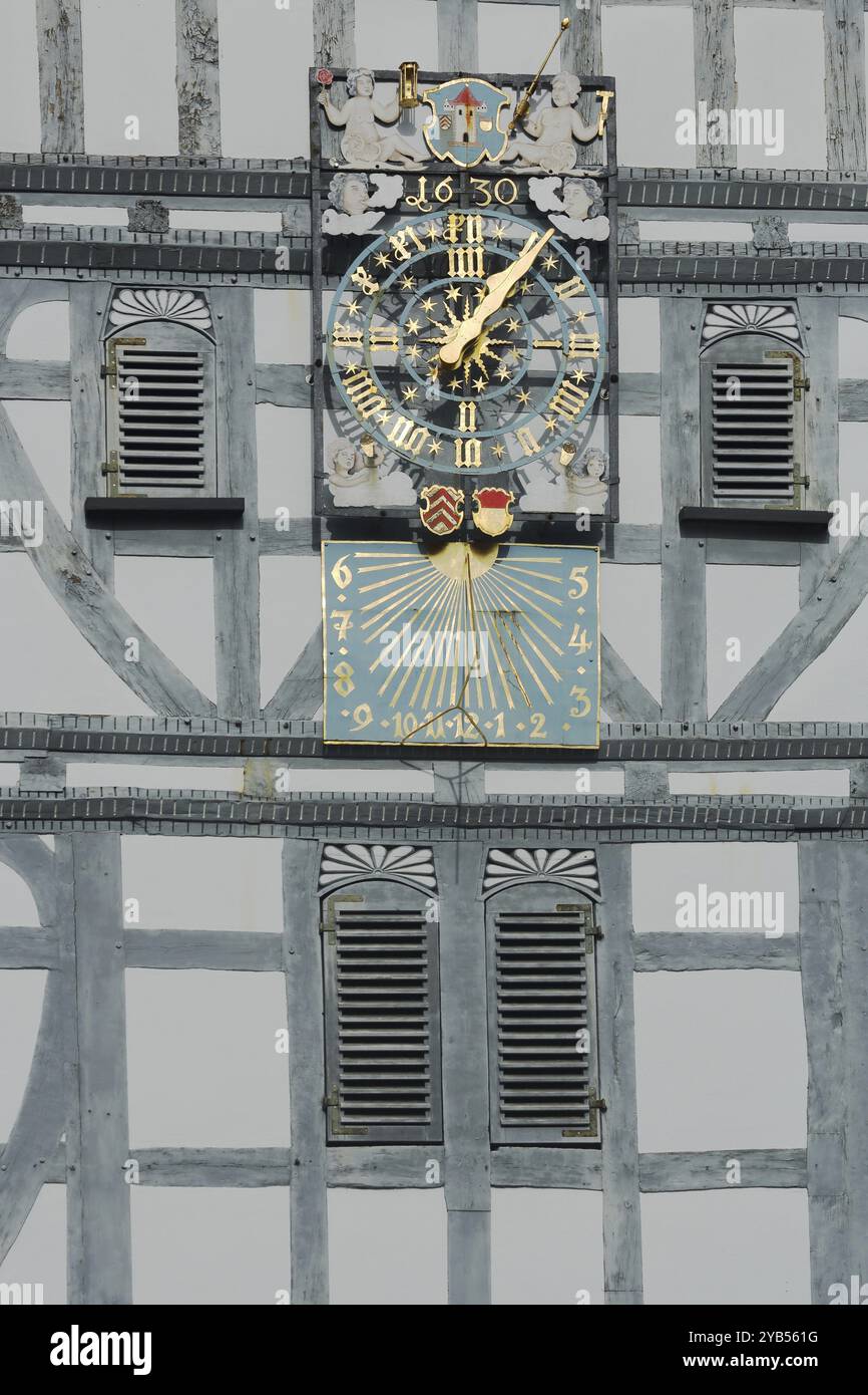 Golden clock with grey half-timbering and shutters, sundial, half ...