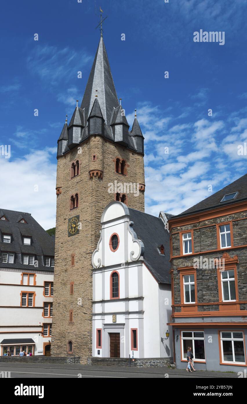 Historic church tower with neighbouring buildings under a blue sky in a ...