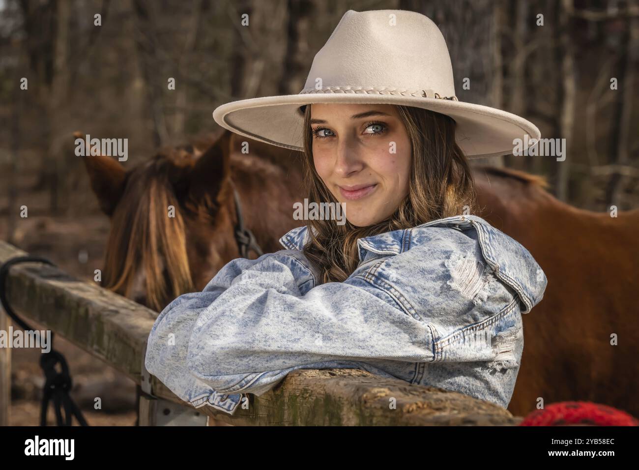 A beautiful brunette cowgirl poses with her horse before a ride in the countryside Stock Photo ...