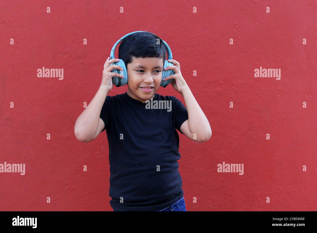 9-year-old brown Latino boy with sound-isolating headphones for autism ...