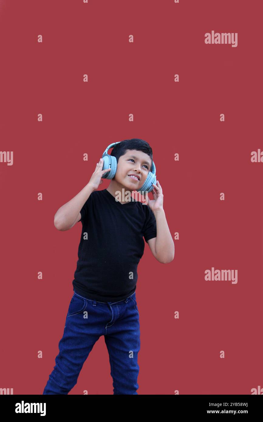 9-year-old brown Latino boy with sound-isolating headphones for autism ...