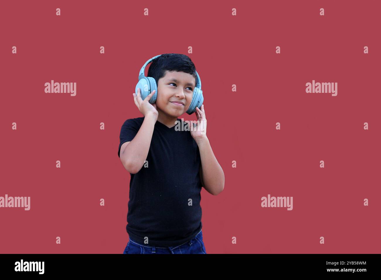 9-year-old brown Latino boy with sound-isolating headphones for autism ...