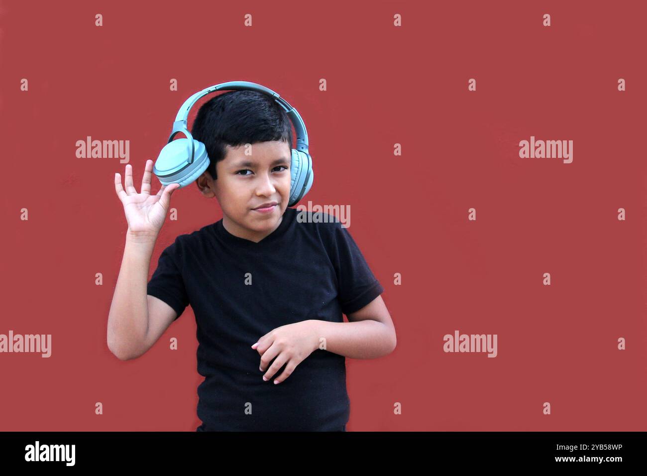 9-year-old brown Latino boy with sound-isolating headphones for autism ...