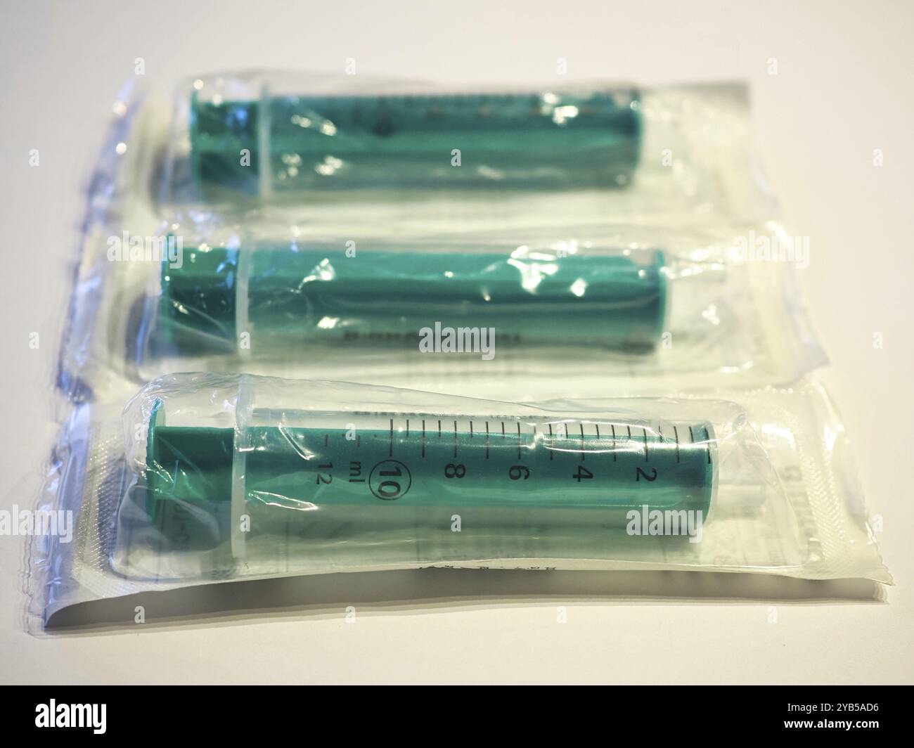 Symbol photo for medicine, three syringes in a sterile package, blurred ...