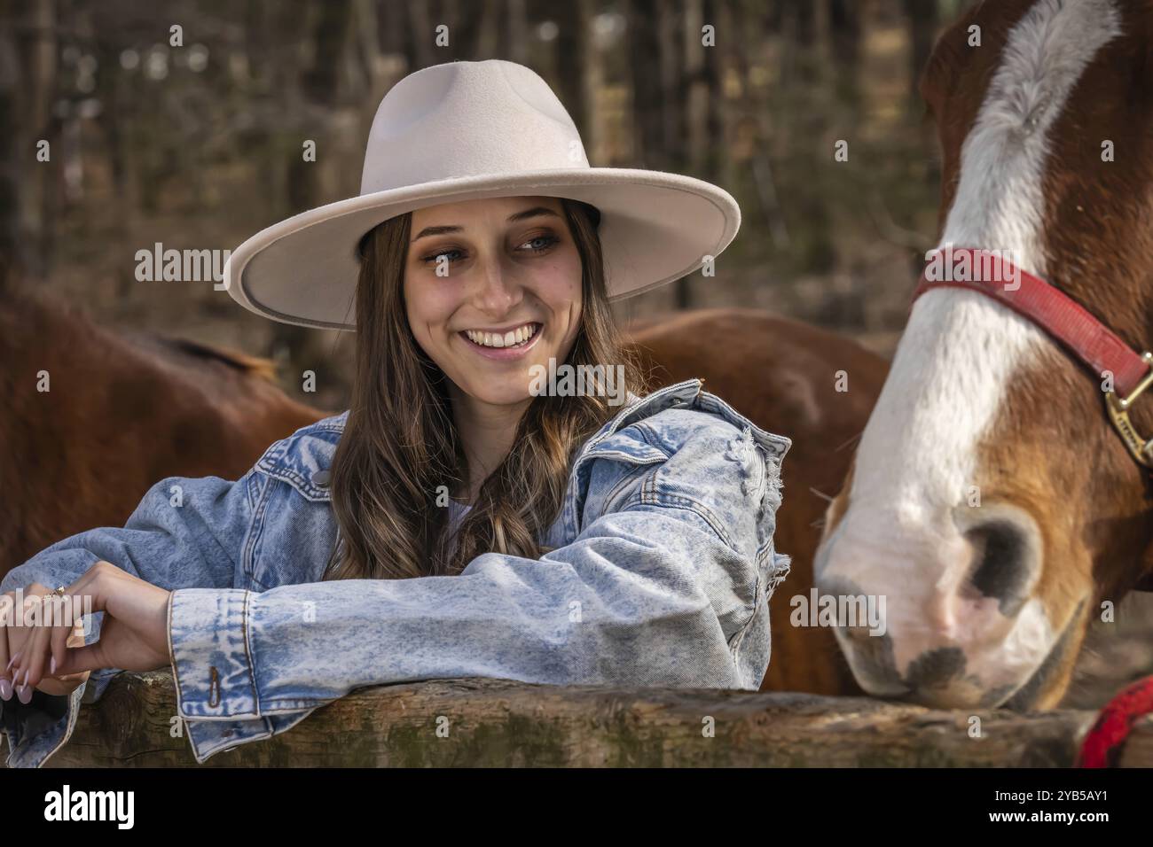 A beautiful brunette cowgirl poses with her horse before a ride in the countryside Stock Photo ...