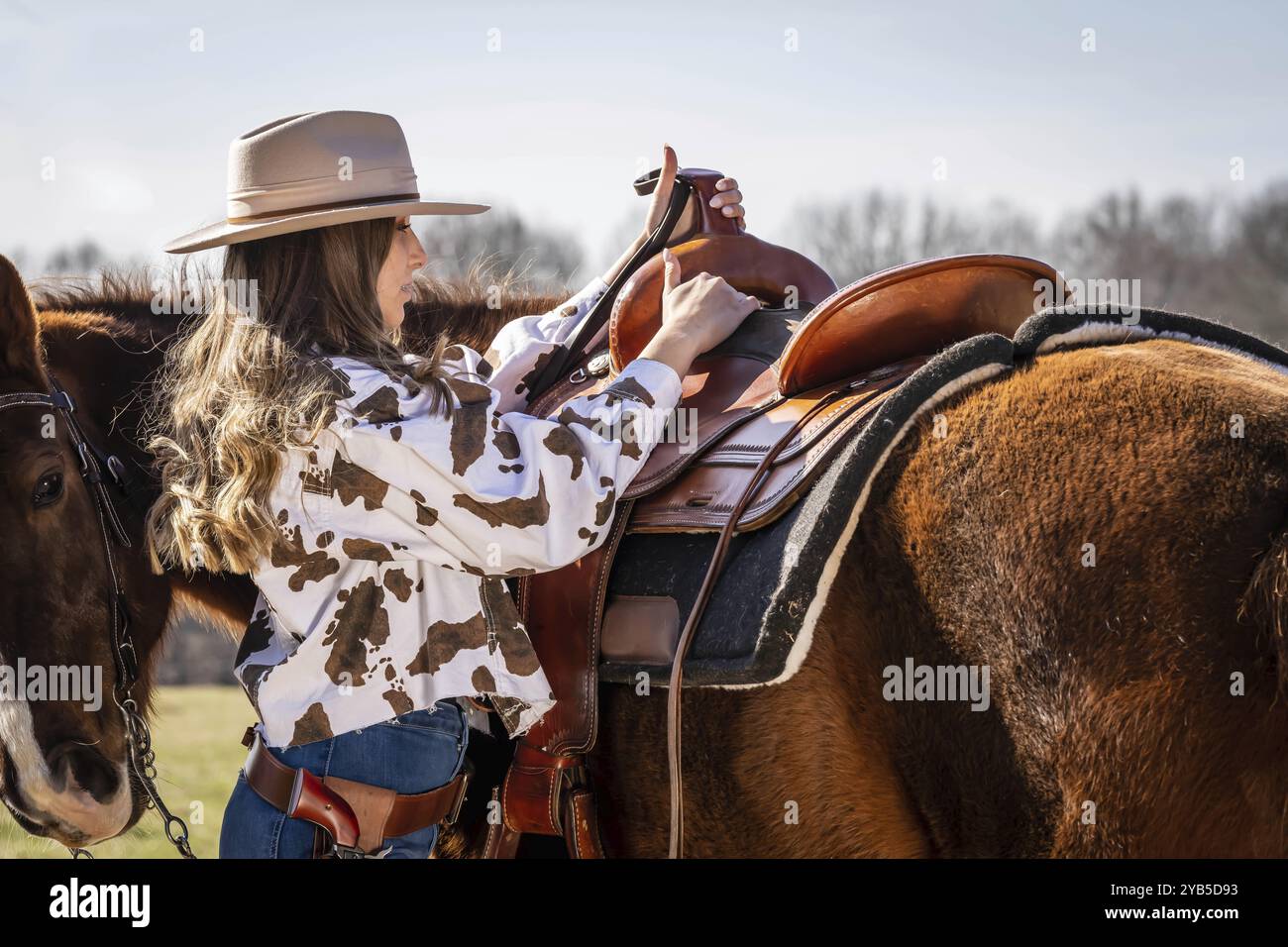 A beautiful brunette cowgirl poses with her horse before riding in the country Stock Photo - Alamy
