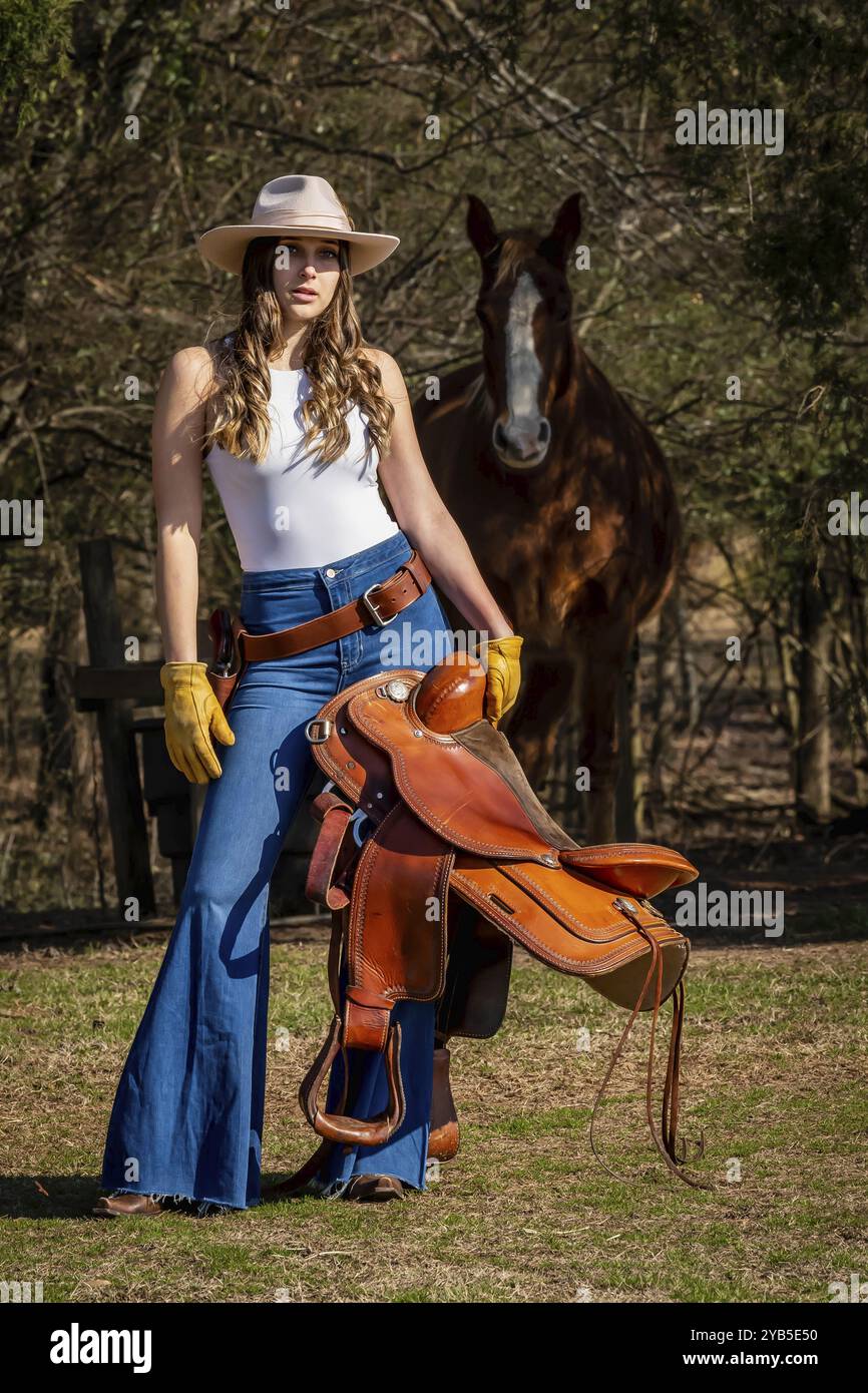 A beautiful brunette cowgirl poses with her horse before riding in the country Stock Photo - Alamy
