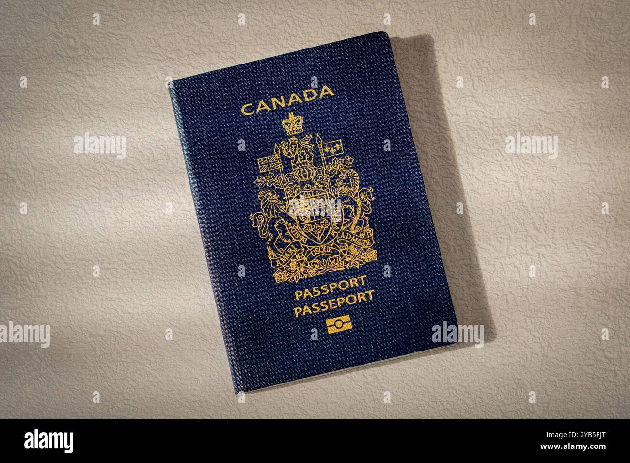 Canadian passport lies elegantly on a textured surface, casting a ...