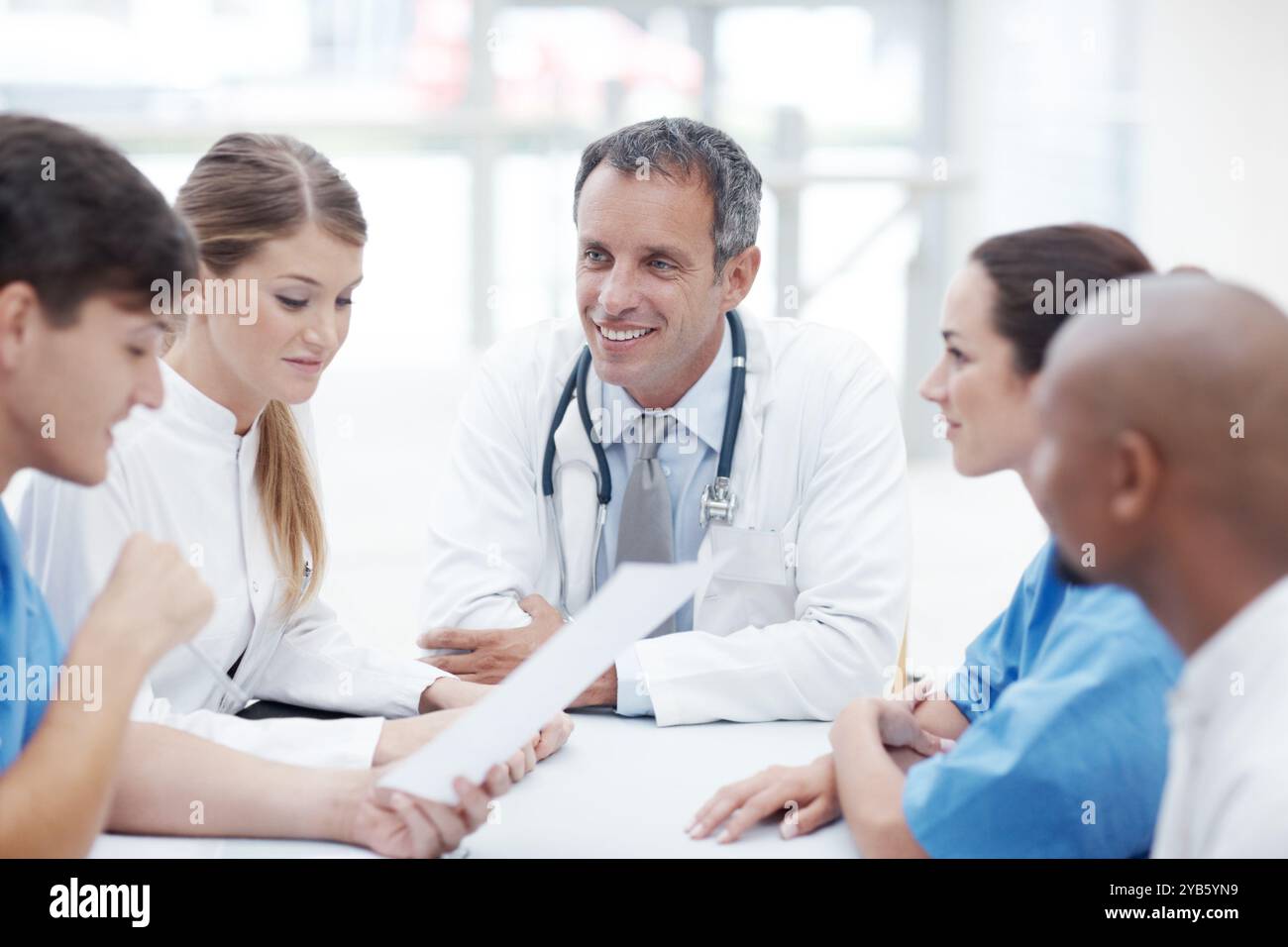 Doctors, team and meeting with paperwork at hospital with review ...