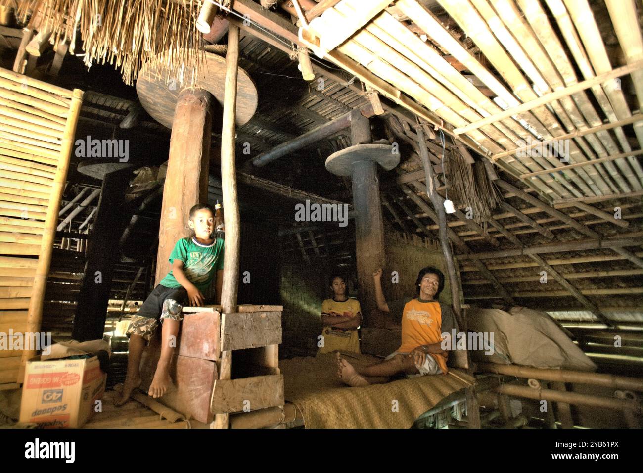 Umbu Tiu, a villager, with his wife and child inside their traditional ...