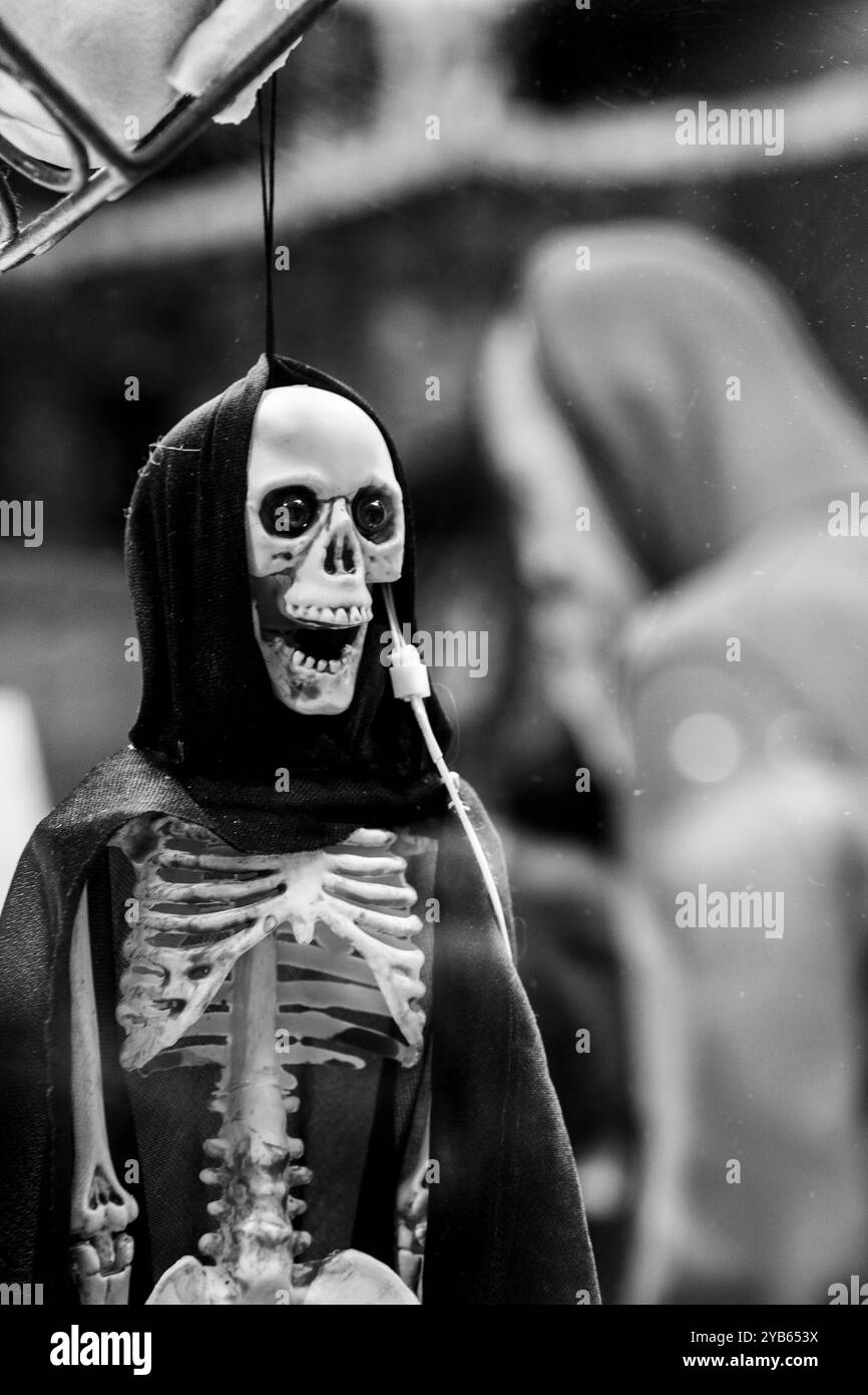 Close-up of skeletal figure dressed as grim reaper in black hood. Black ...