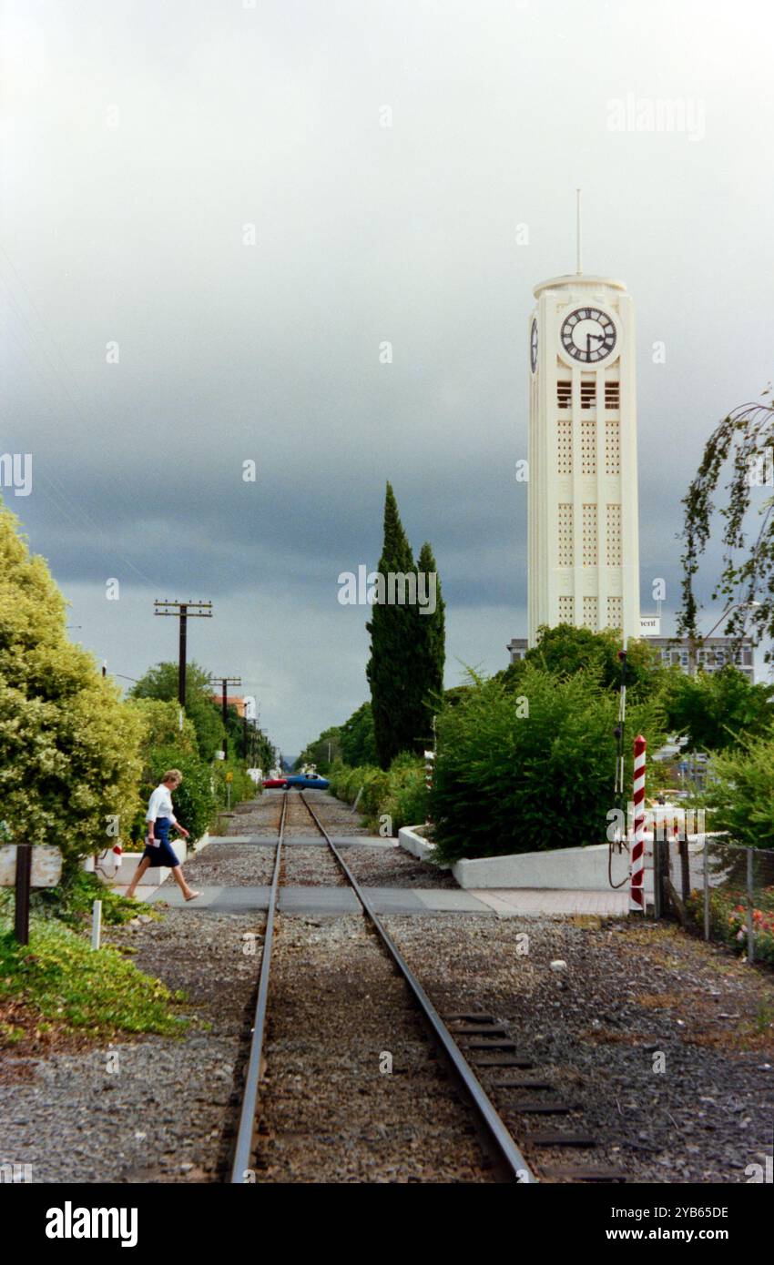 Railway line passing through the town of Hastings in New Zealand and the Hastings Clock Tower, a ...